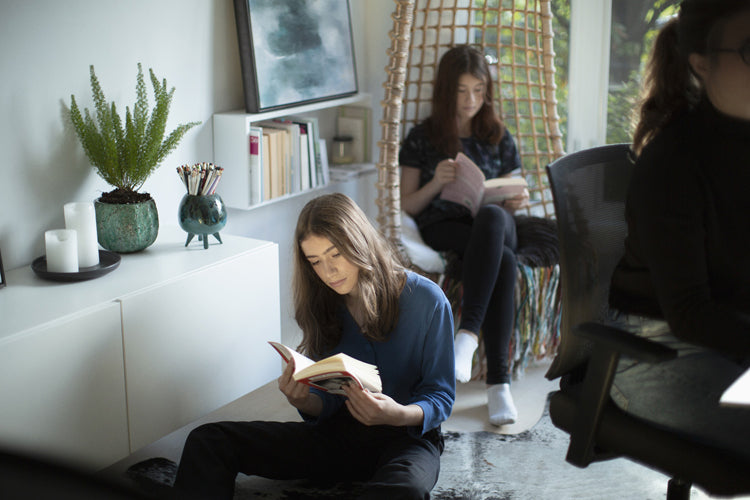 Family reading in living room – Studio Pre&ent
